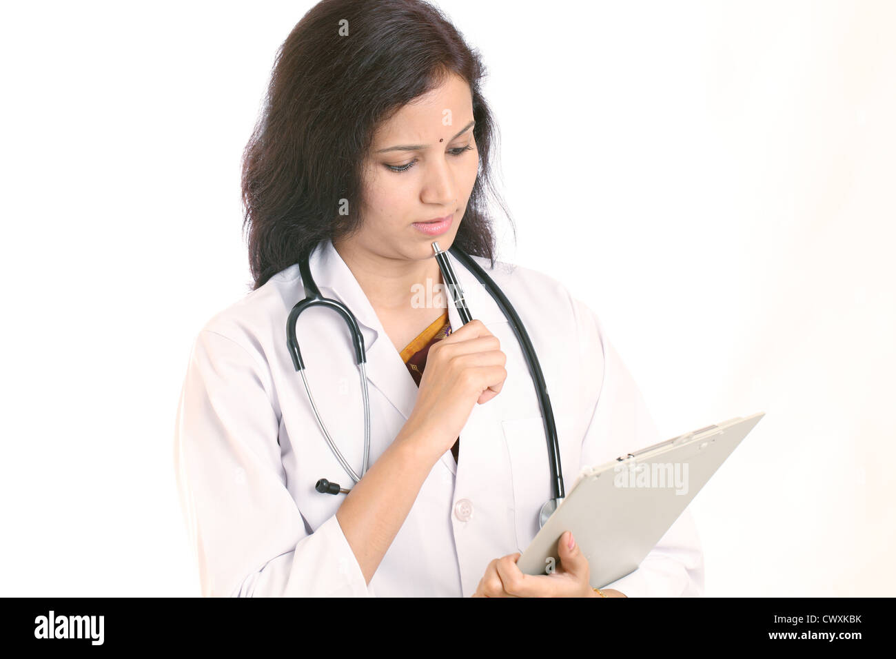 Young female doctor holding a clipboard against white Stock Photo - Alamy
