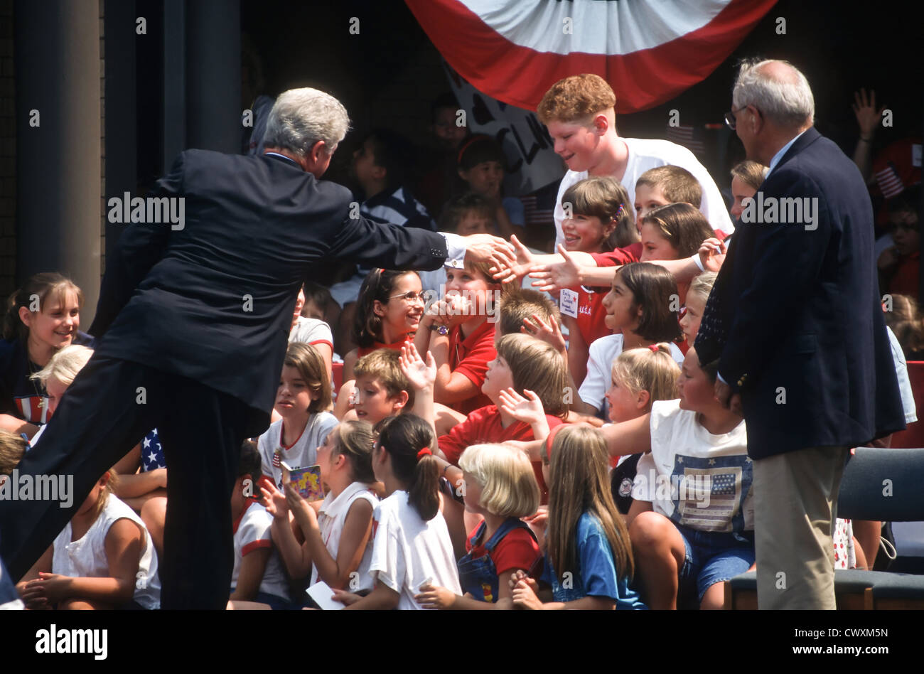President Bill Clinton shakes hands with school children during a ...