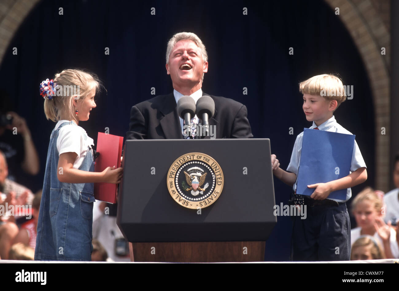 President Bill Clinton laughs as he is introduced by school children ...