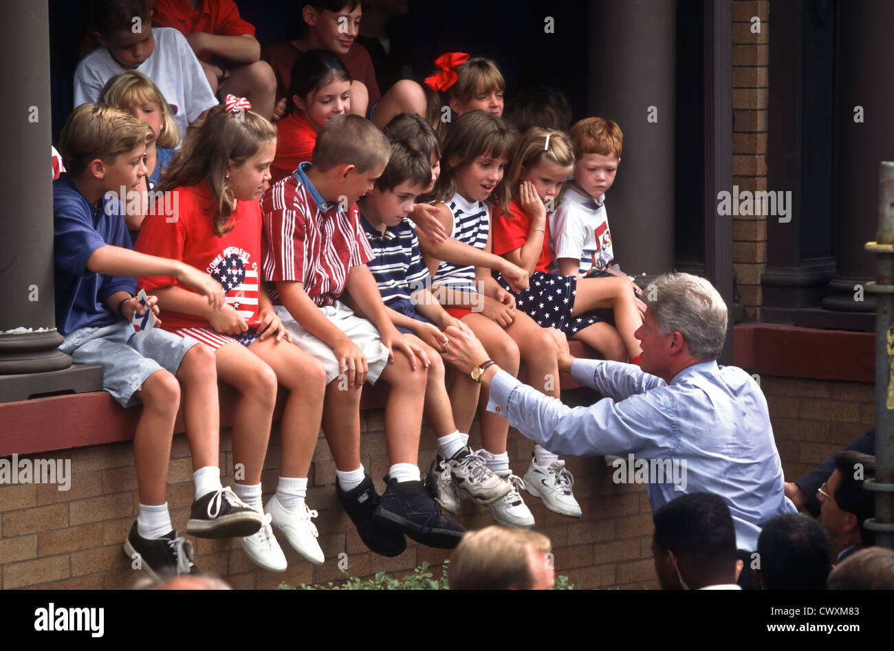 President Bill Clinton shakes hands with school children during a ...
