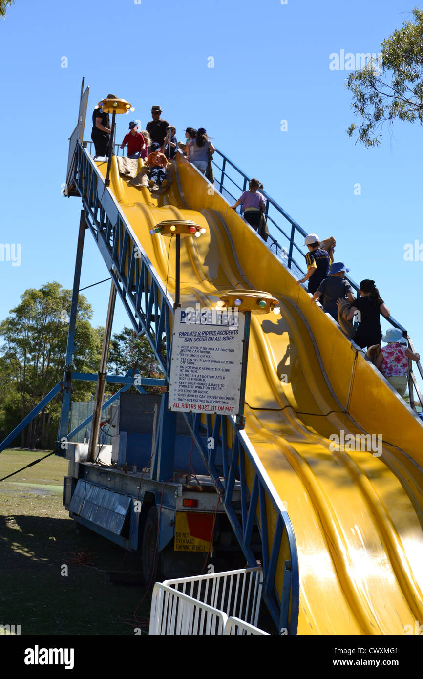 People climbing up ladder waiting in line while other slide down the ...
