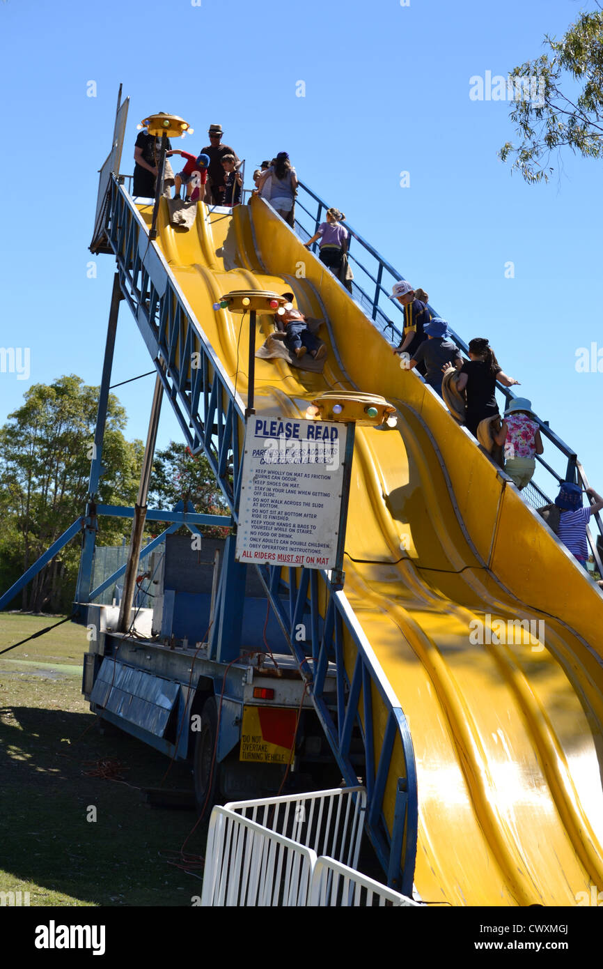 People climbing up ladder waiting in line while other slide down the ...