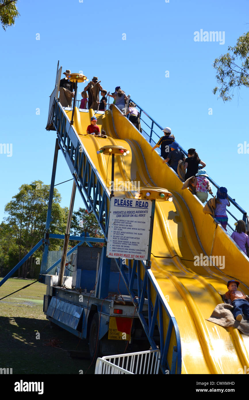 People climbing up ladder waiting in line while other slide down the ...