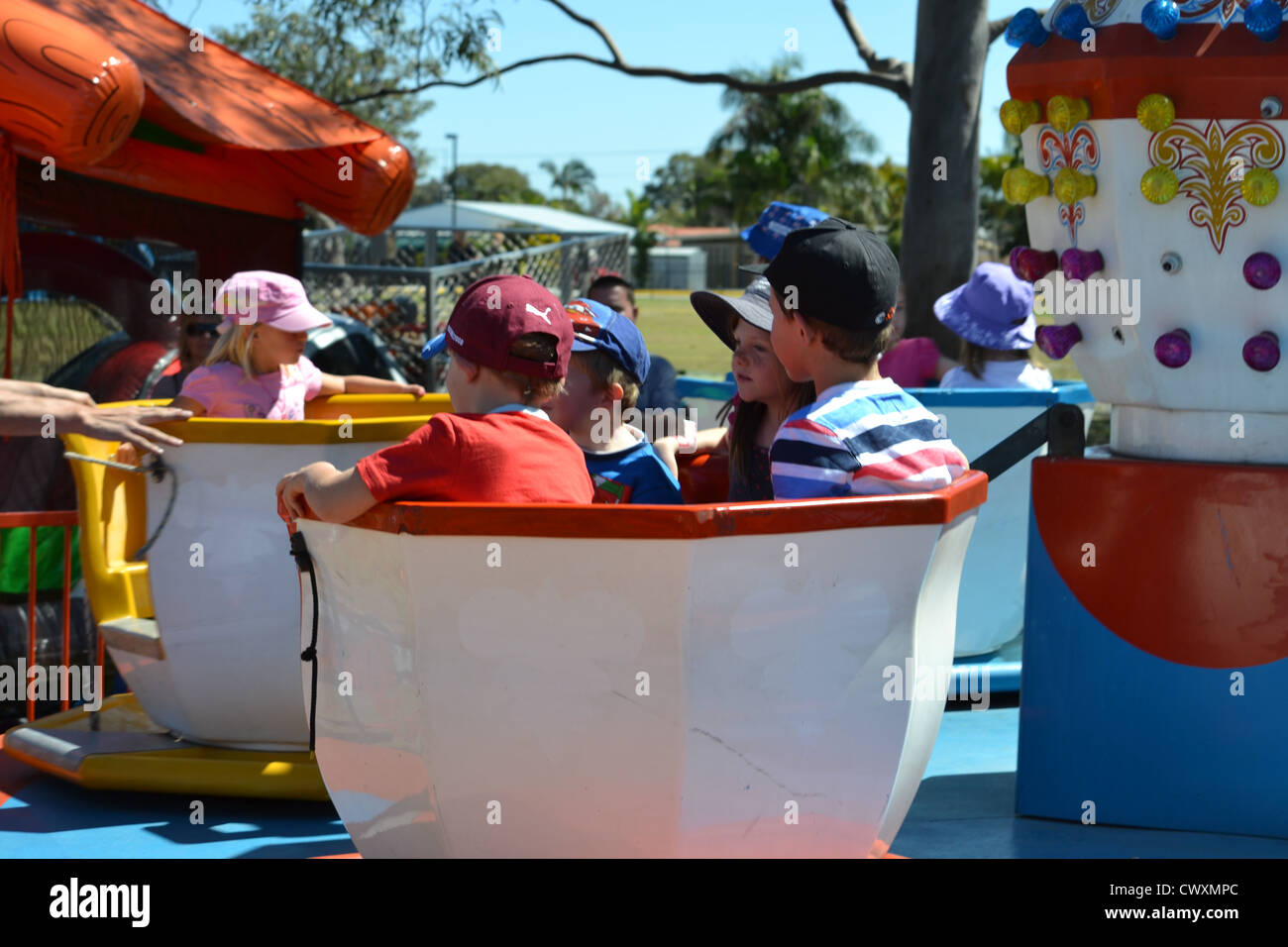 young children on the Cup and Saucer ride at a school fete / fair Stock ...