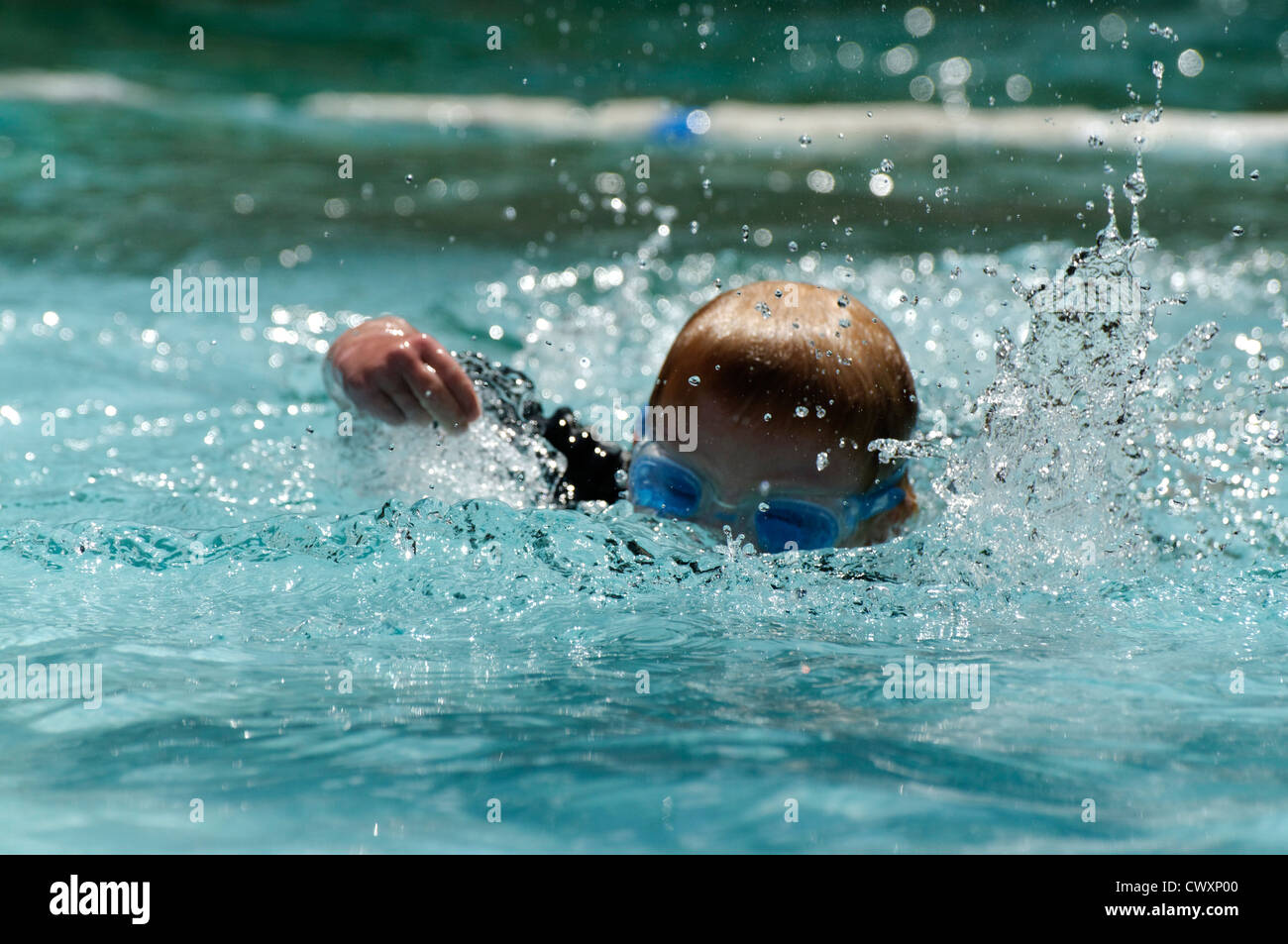 A young boy swimming in an outdoor pool Stock Photo - Alamy