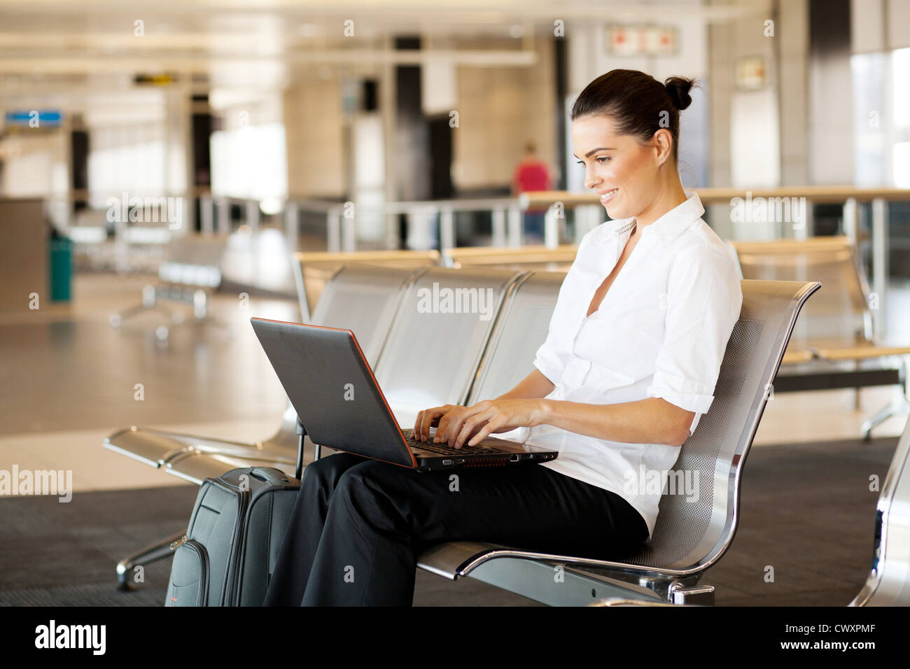 young woman using laptop computer at airport Stock Photo - Alamy