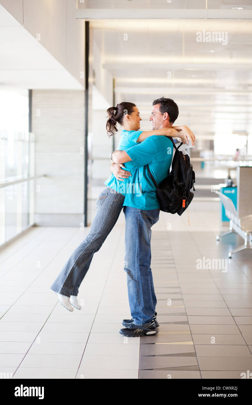 happy young couple hugging at airport Stock Photo - Alamy