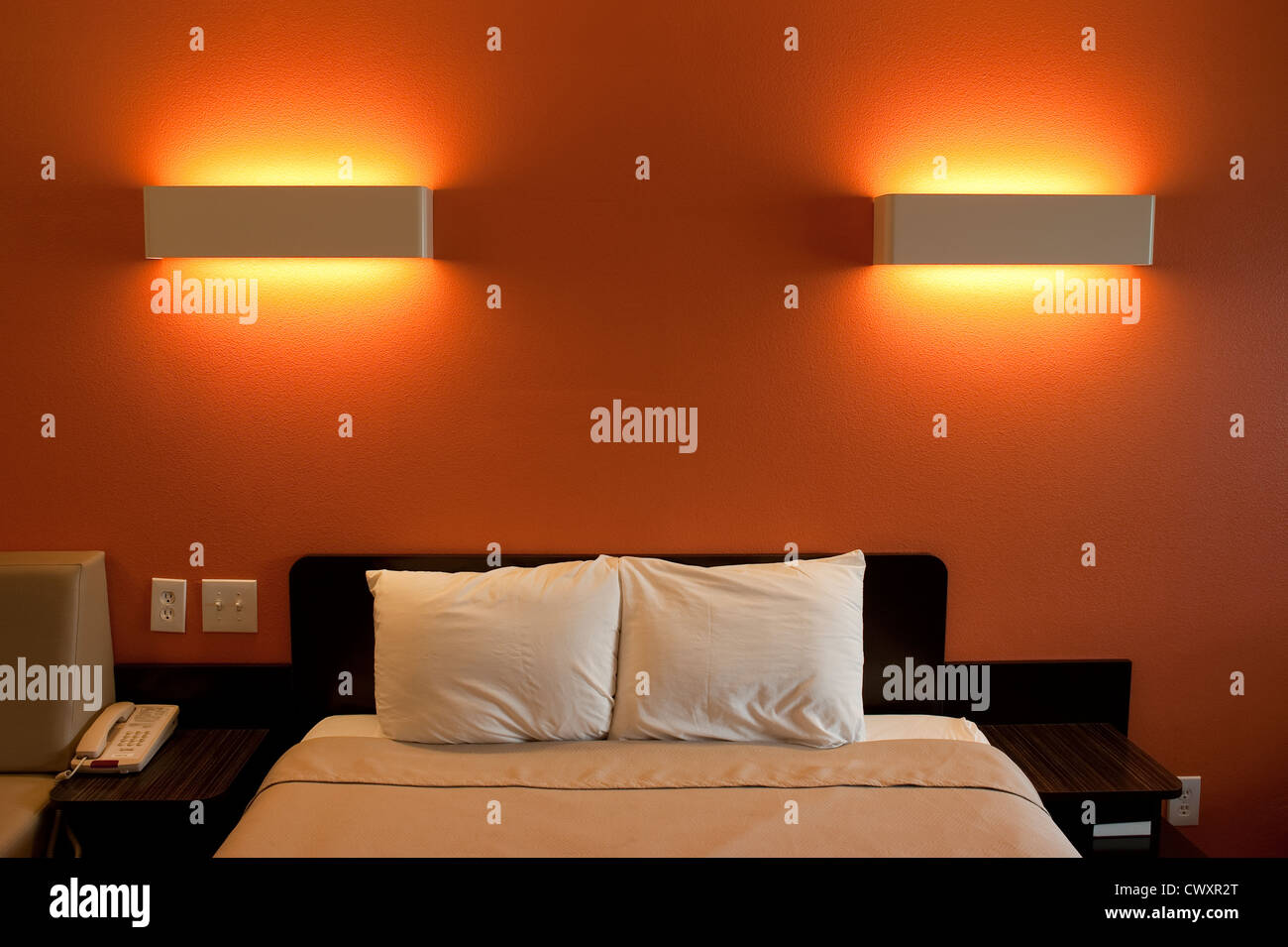 Motel room with bed and wall lights and night stands Stock Photo - Alamy