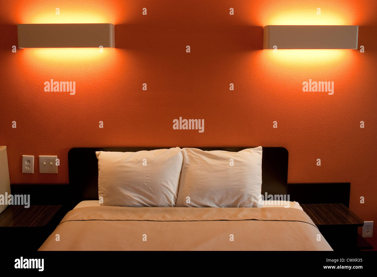 Motel room with bed and wall lights and night stands Stock Photo - Alamy