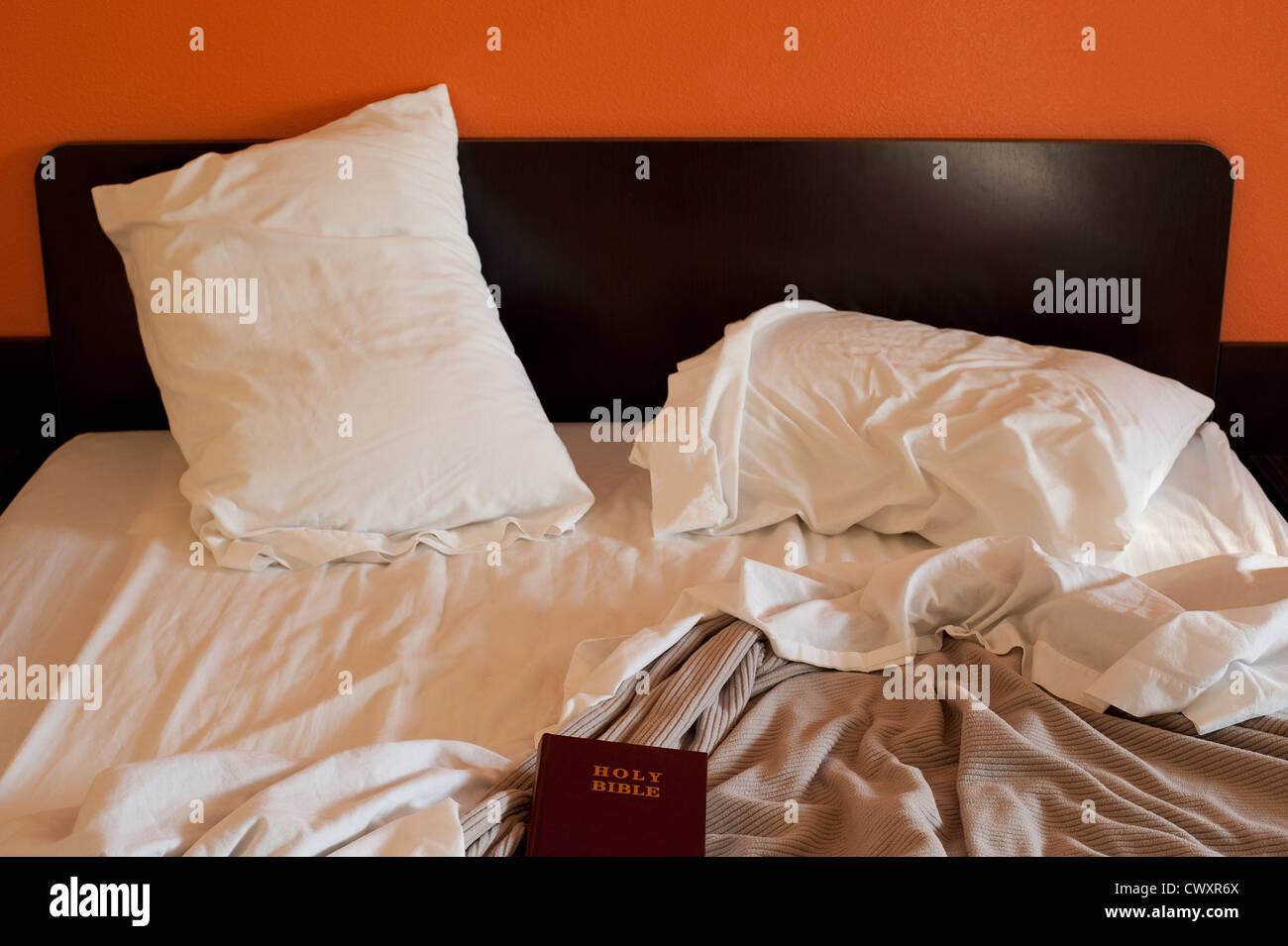 Motel room with bible and messy bed Stock Photo - Alamy