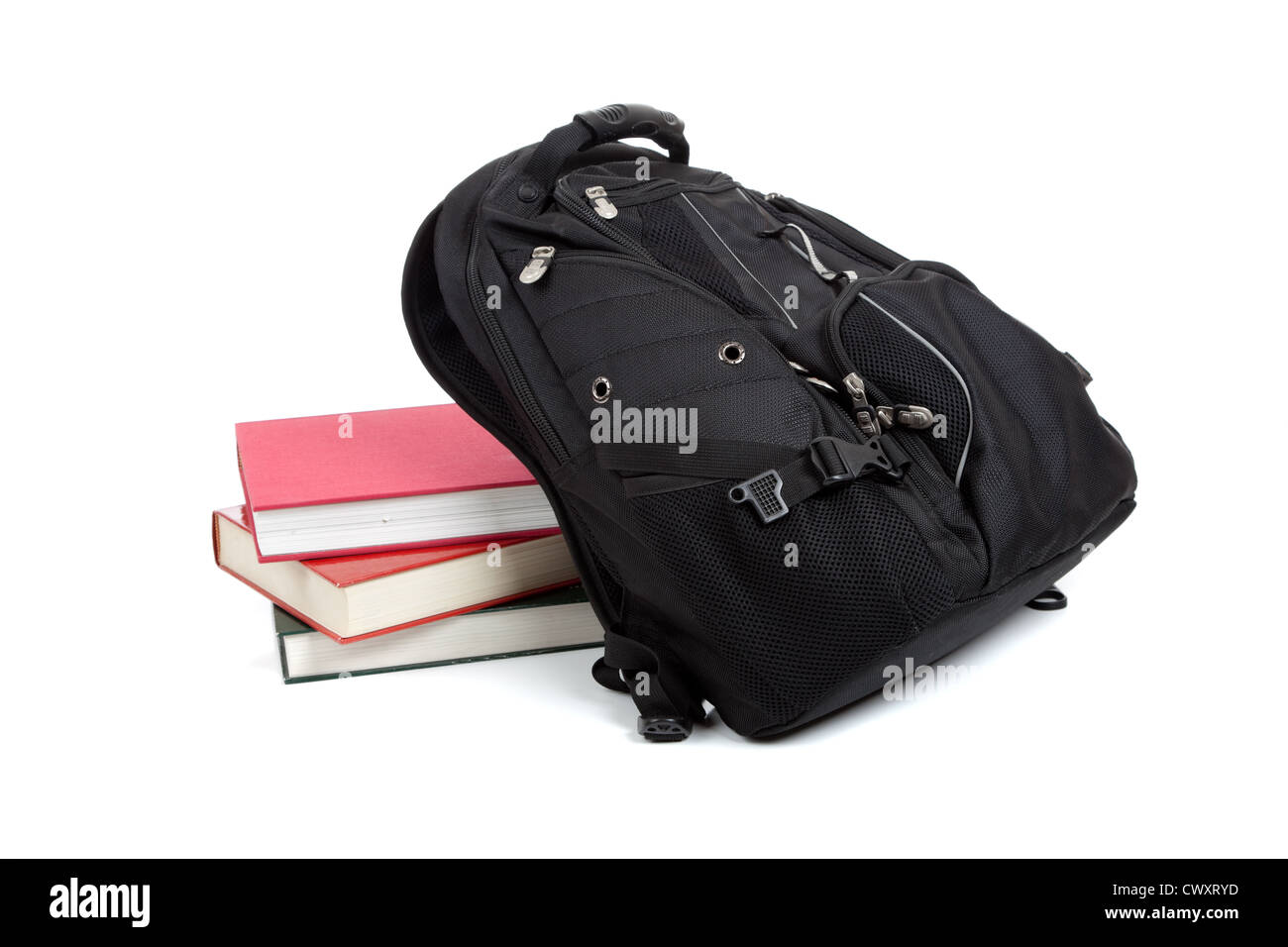 A black backpack and a stack of school books on a white background ...