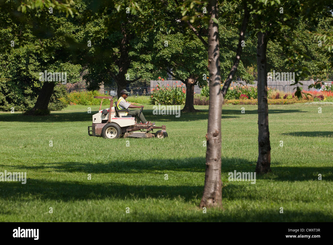 Man mowing field on riding mower Stock Photo - Alamy