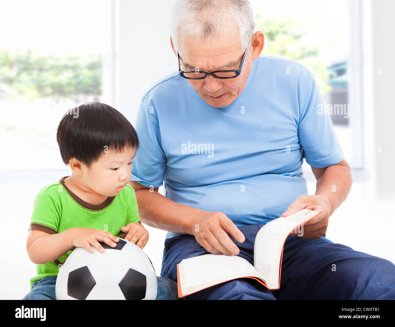 grandfather reading a story book for his grandson Stock Photo - Alamy