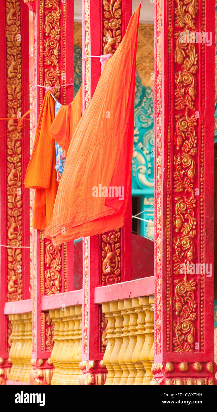 Robes of Buddhist monks hanging to dry between the columns of a temple ...