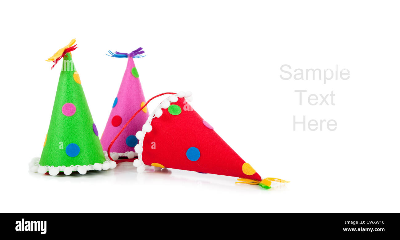 Assorted colored polka dotted party hats on a white background with ...