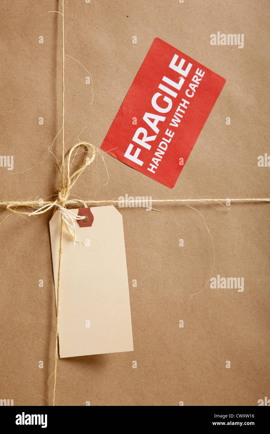 A kraft paper background with a shipping label and a red Fragile ...