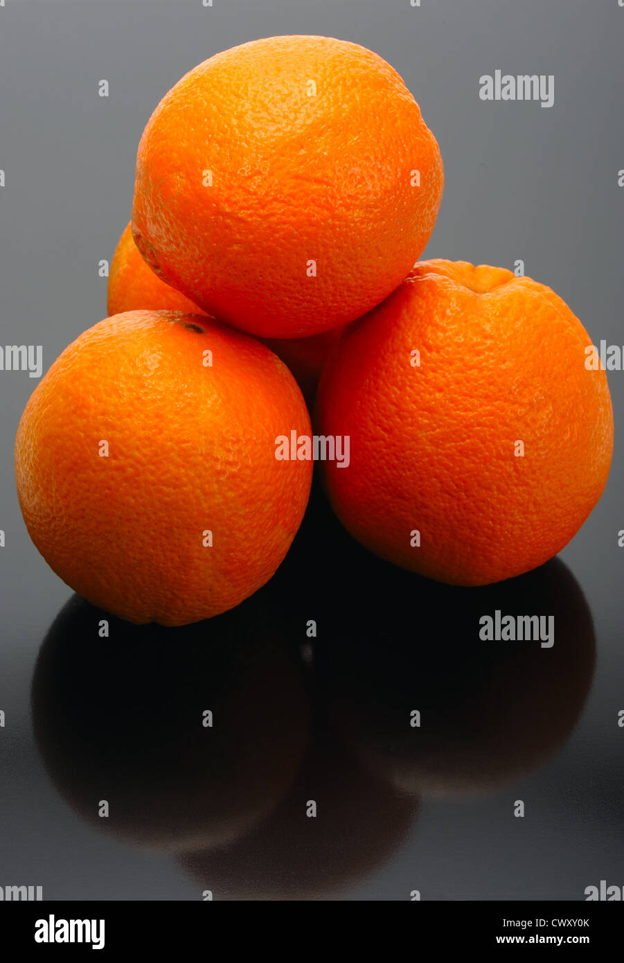 Four oranges and their reflection on a black background Stock Photo - Alamy
