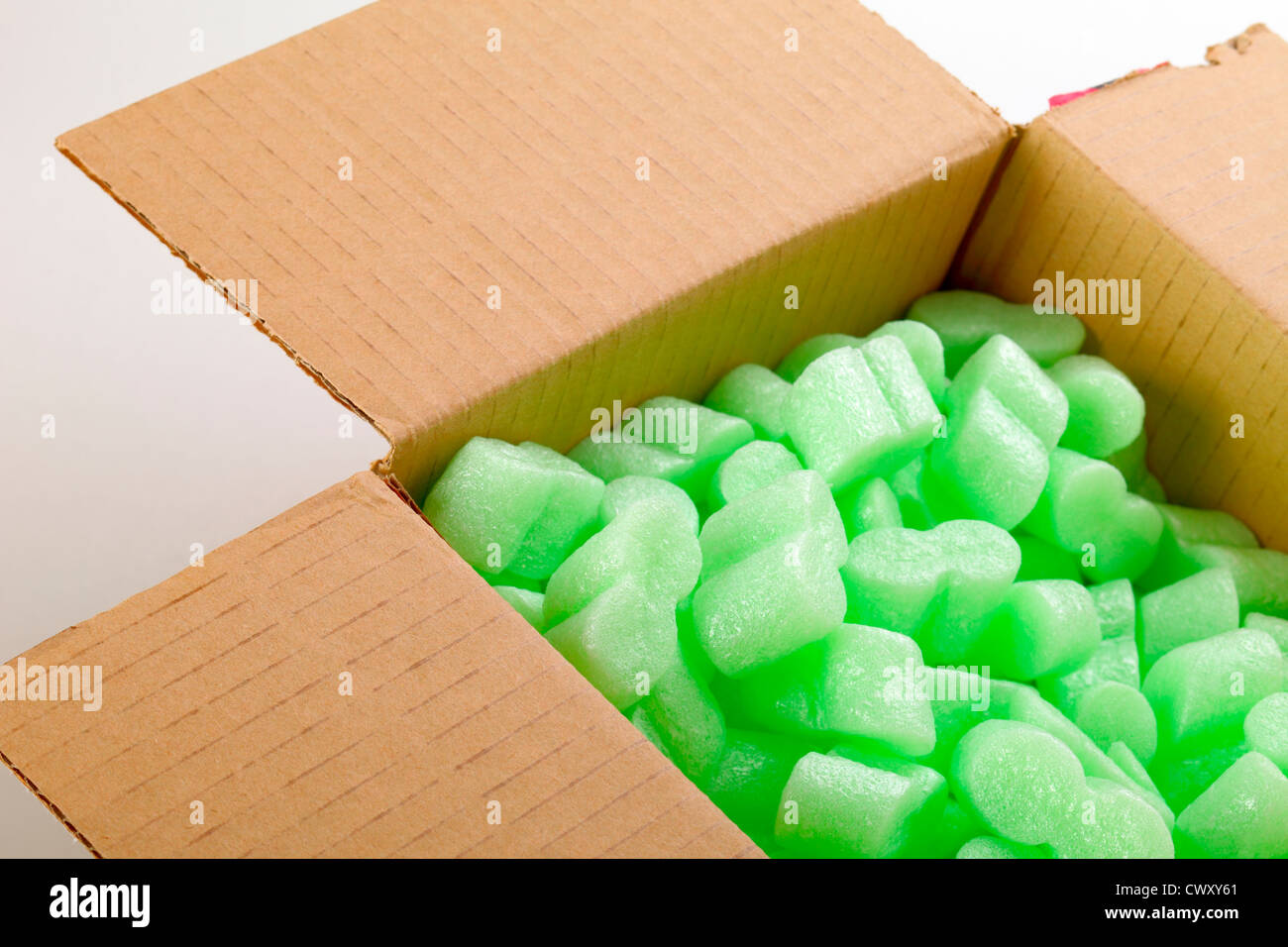 A cardboard box with green packing styrofoam peanuts Stock Photo - Alamy