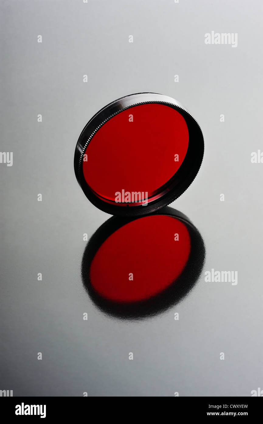 Red filter and its reflection on a black background Stock Photo - Alamy