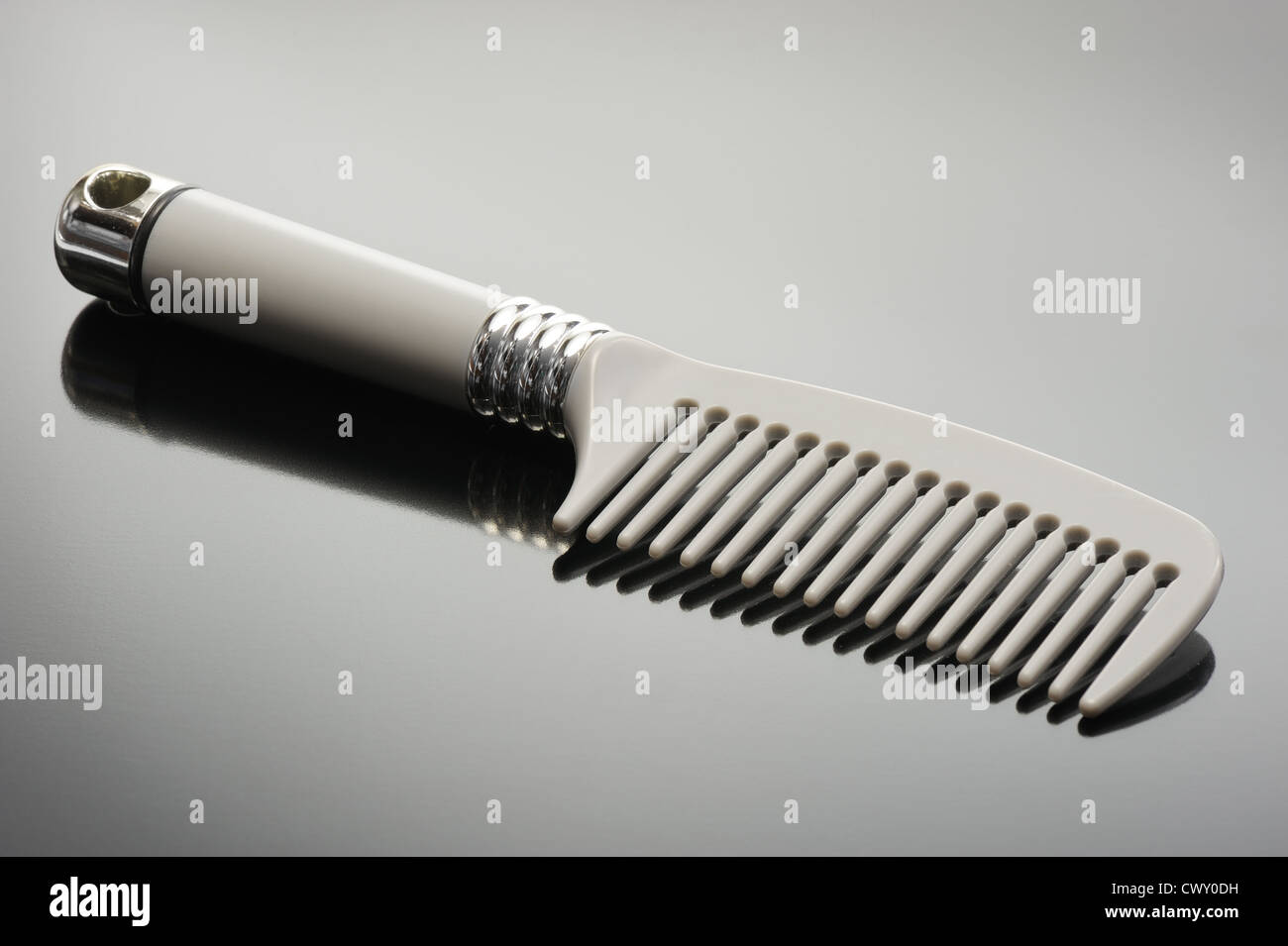 Grey comb and its reflection on a black background Stock Photo - Alamy