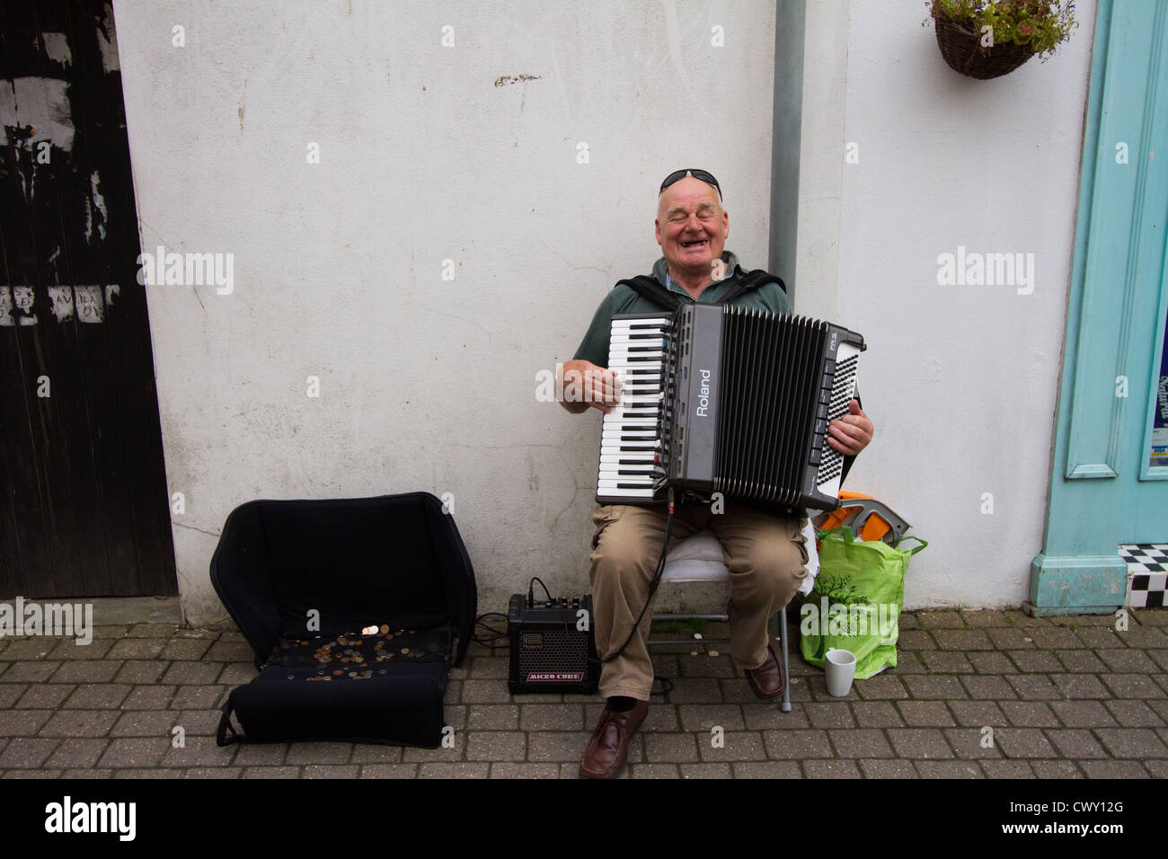 A busker with accordion on a street of a seaside town Stock Photo - Alamy