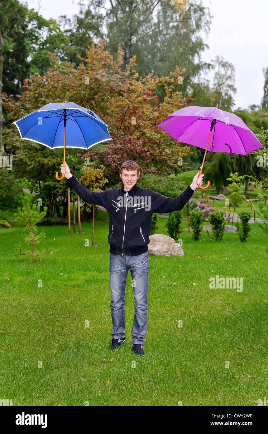 Young man with two umbrellas outdoors Stock Photo - Alamy