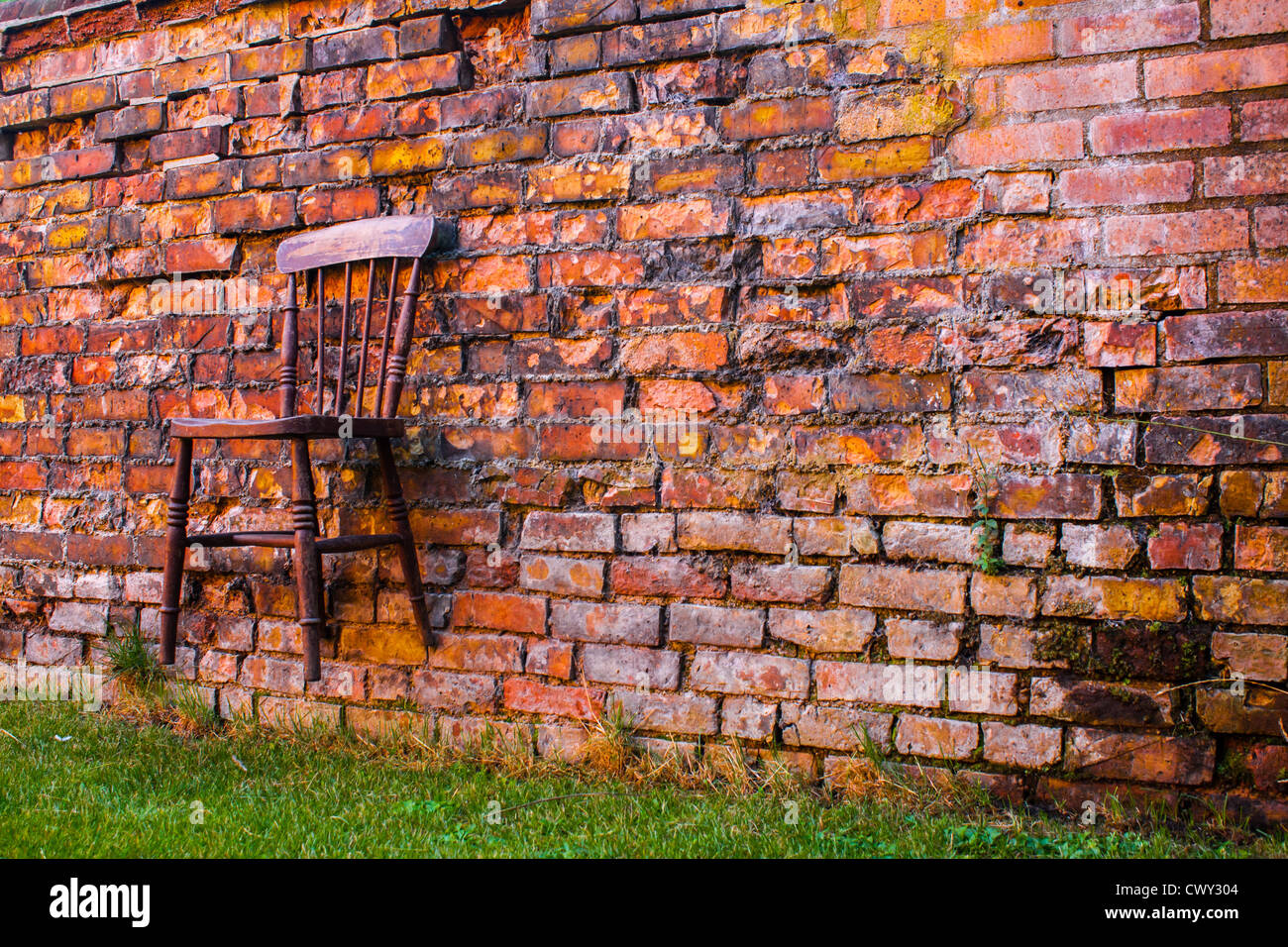 Chair hanging on the brick wall Stock Photo - Alamy