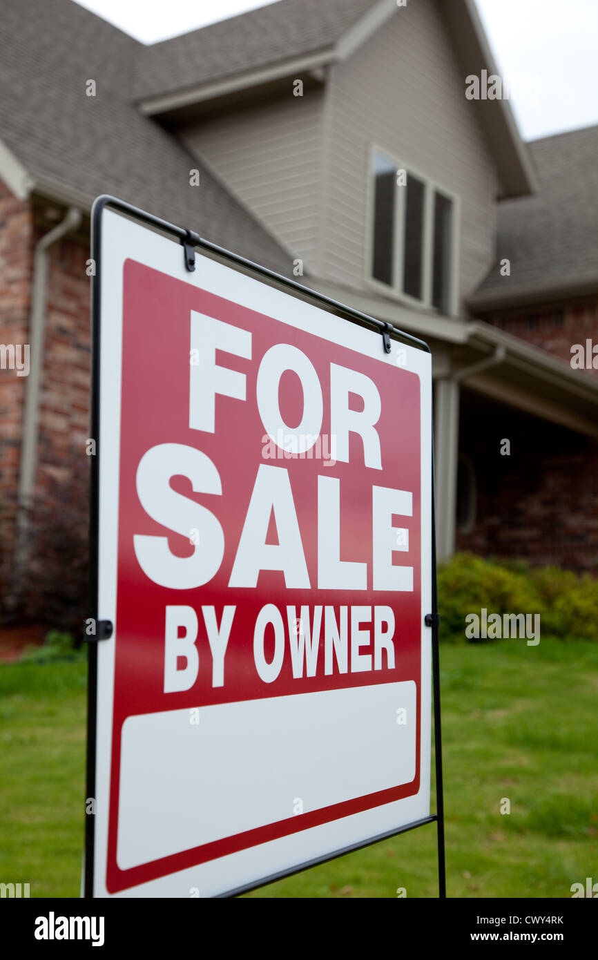 A For Sale sign with a home in the background Stock Photo - Alamy