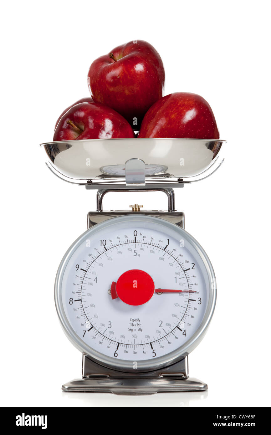 A silver food scale with red apples in it on a white background Stock ...