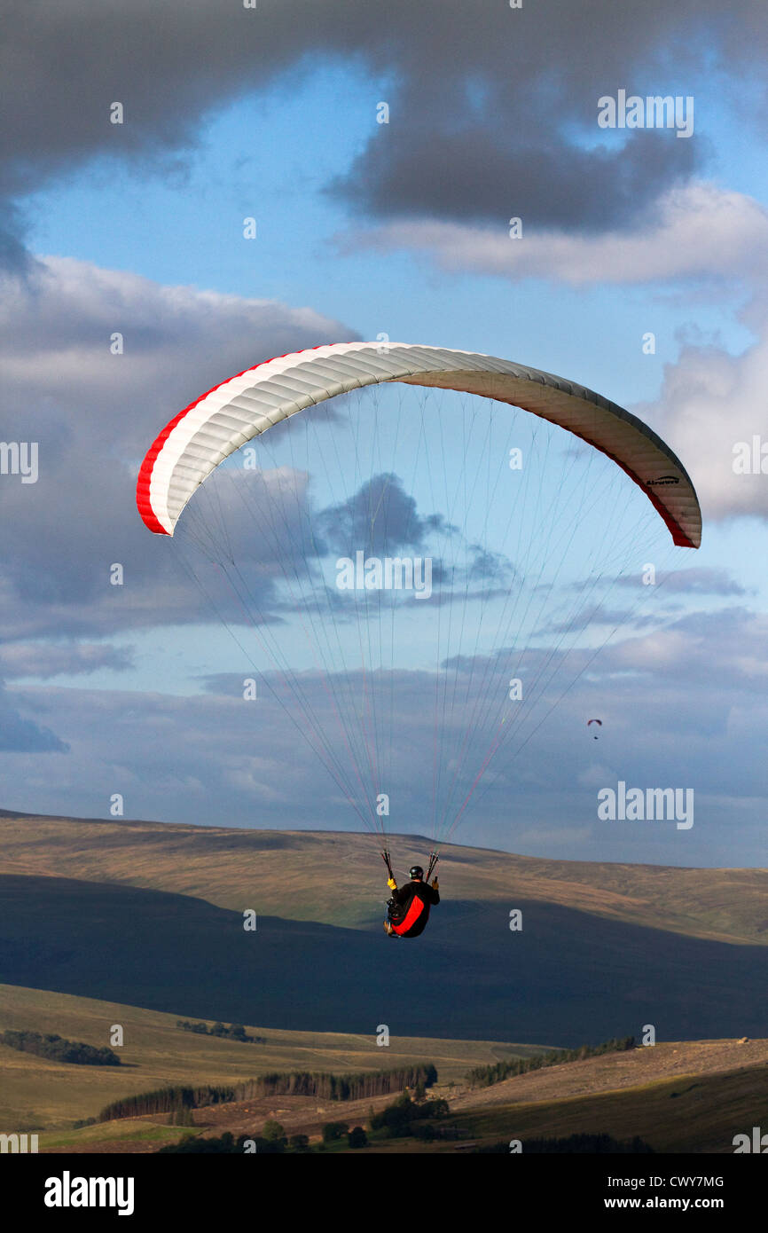 Paraglider flying with red & white Airwave wing over windward slopes at ...