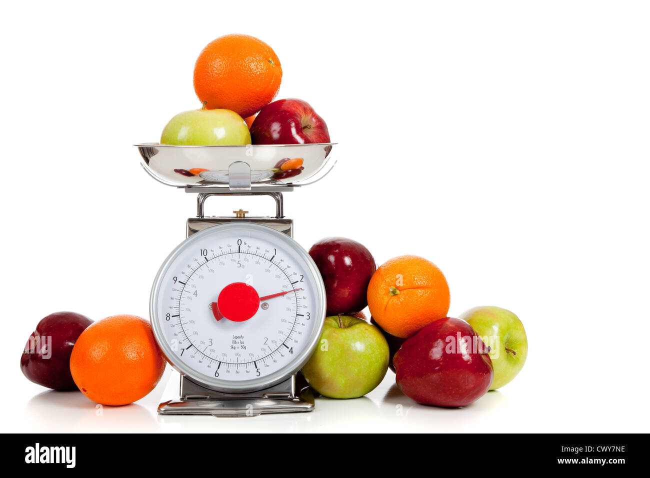 Assorted fruits on a food scale on a white background Stock Photo - Alamy