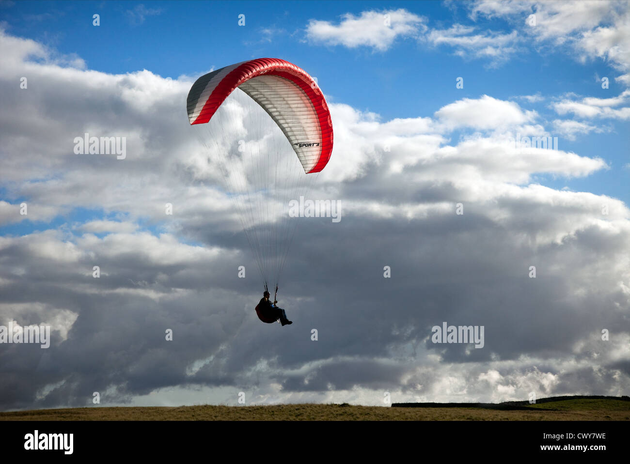 Paraglider flying with red & white Airwave wing over windward slopes at ...