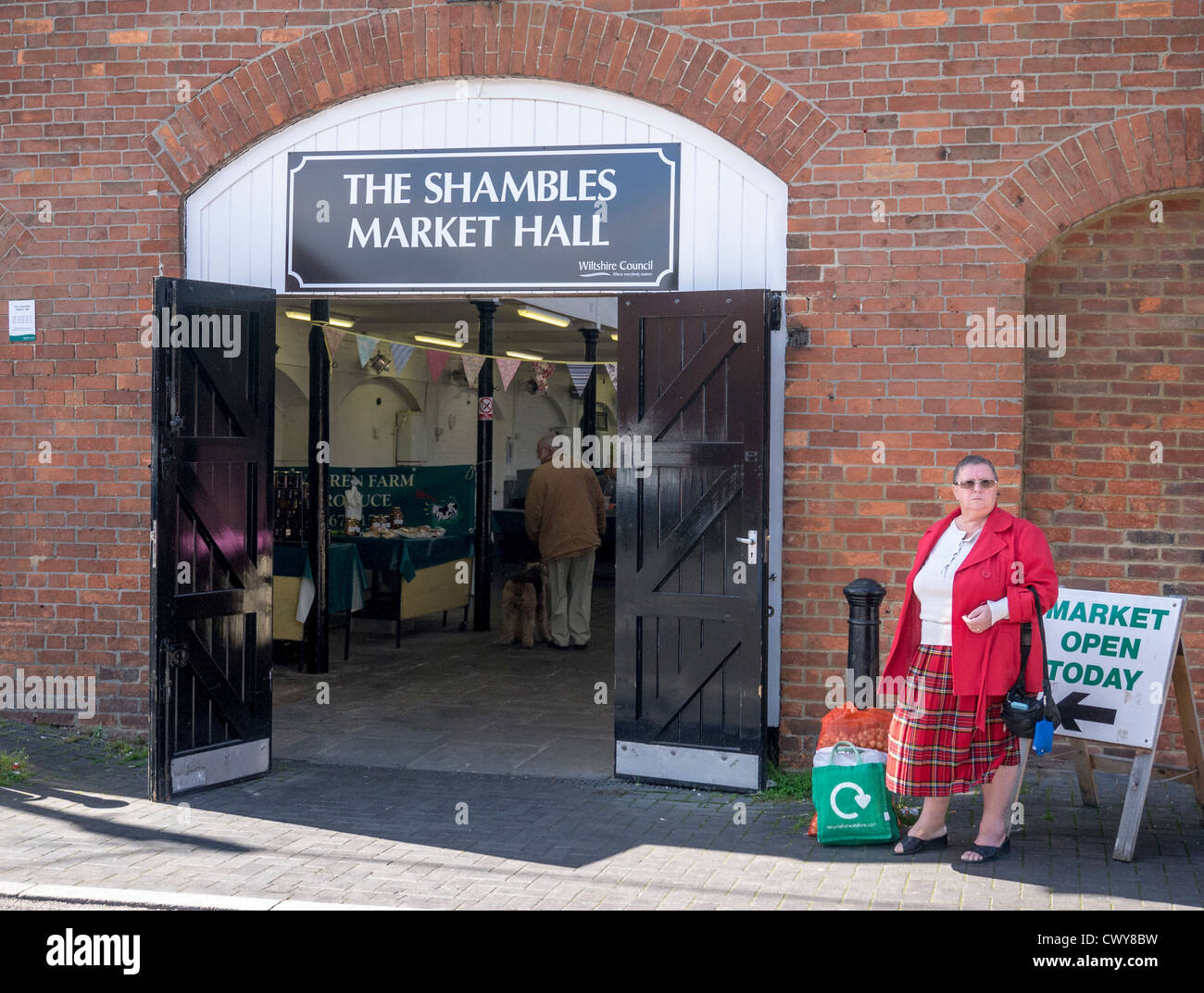 A shopper in red waiting outside the Shambles Market in Devizes ...
