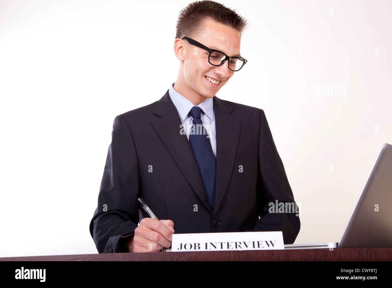 Portrait of a young attractive male secretary with a sign job interview ...