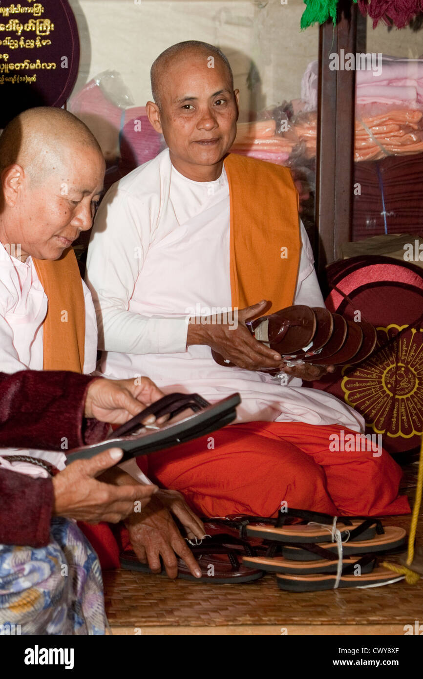 Myanmar, Burma. Mandalay. Two Buddhist Nuns and Friend Examining ...