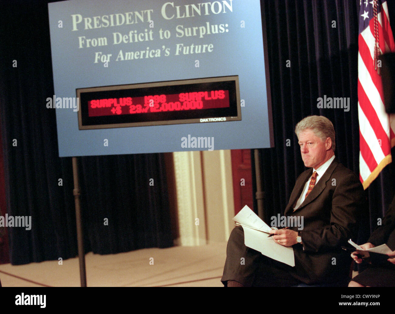 US President Bill Clinton standing in front of the new Budget Surplus ...