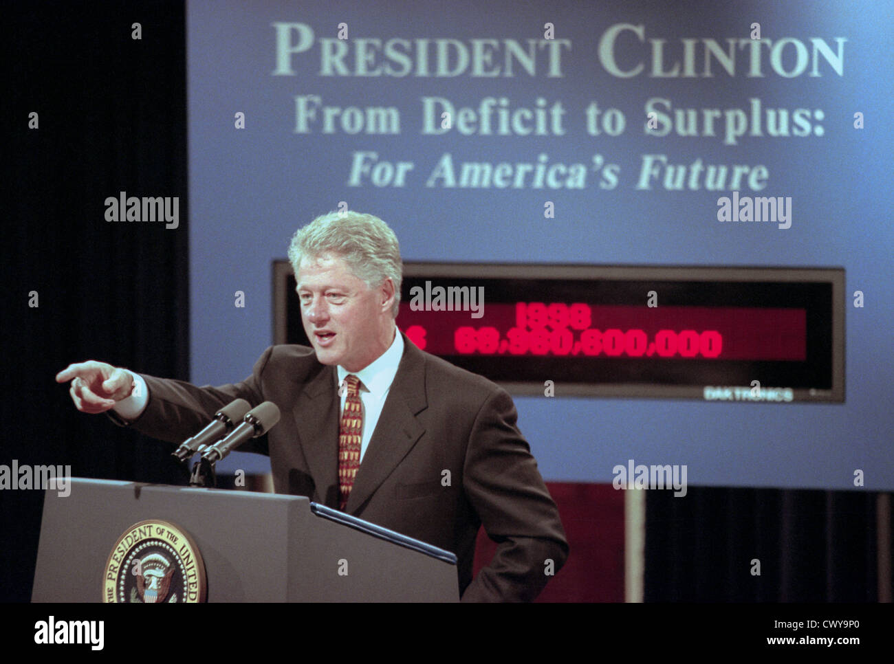 US President Bill Clinton standing in front of the new Budget Surplus ...