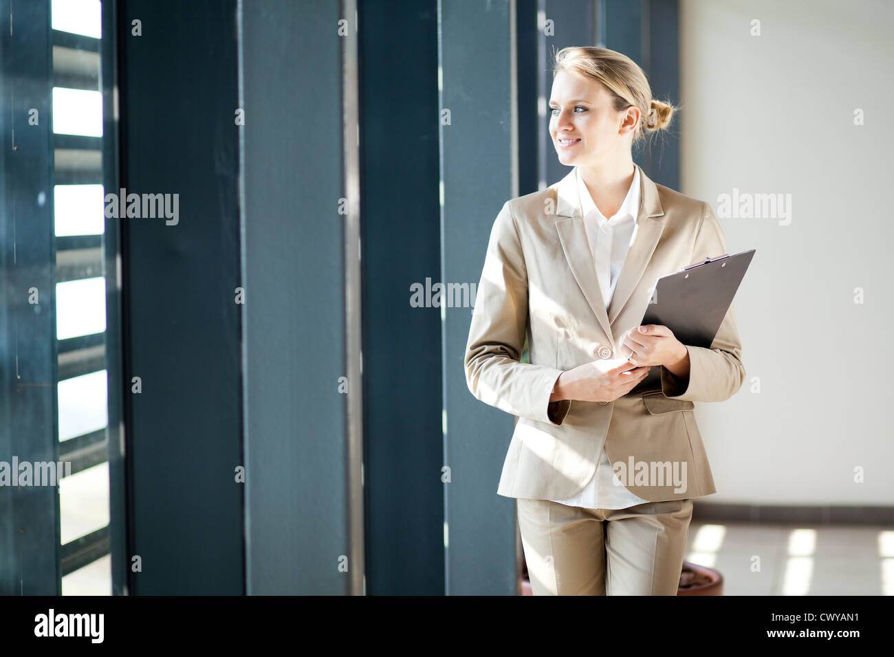 beautiful young businesswoman looking outside office window Stock Photo ...