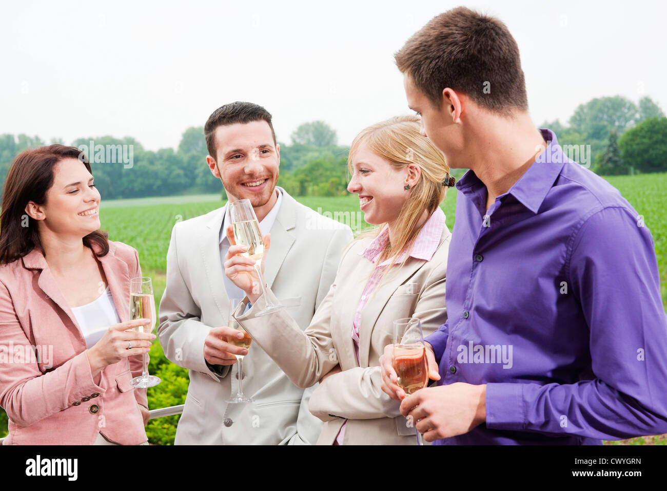 Friends with champagne glasses talking Stock Photo - Alamy