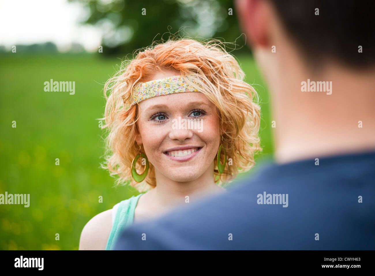 Young woman smiling at man outdoors Stock Photo - Alamy