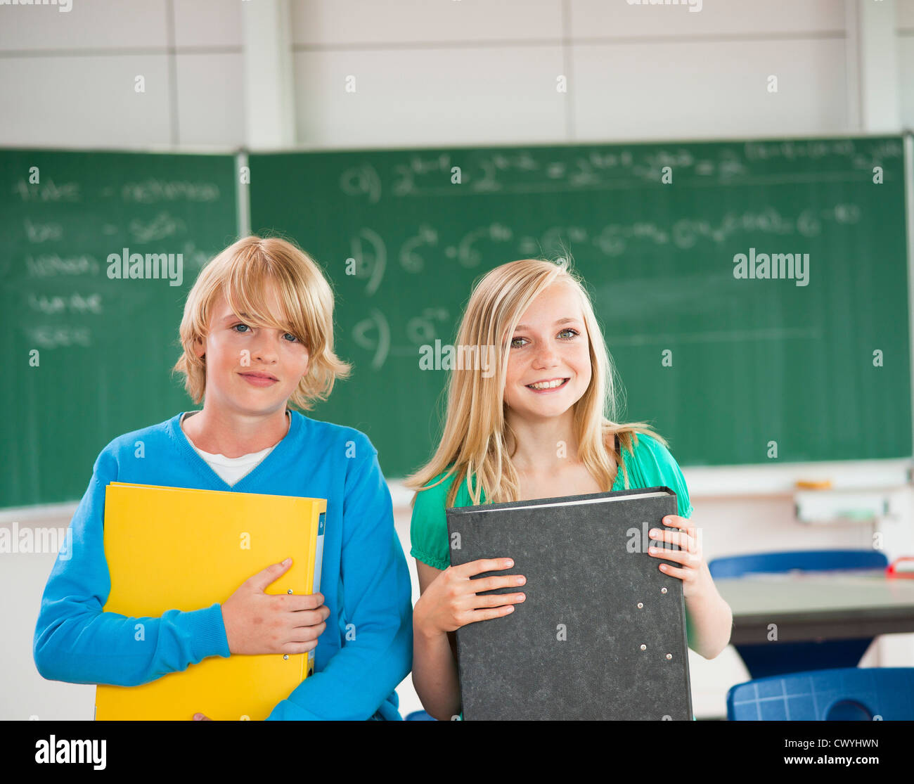 Two smiling pupils in classroom with file folders Stock Photo - Alamy