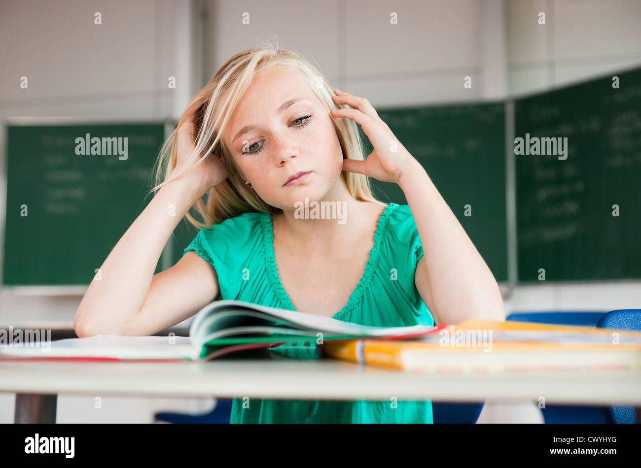Teenage girl in classroom thinking Stock Photo - Alamy