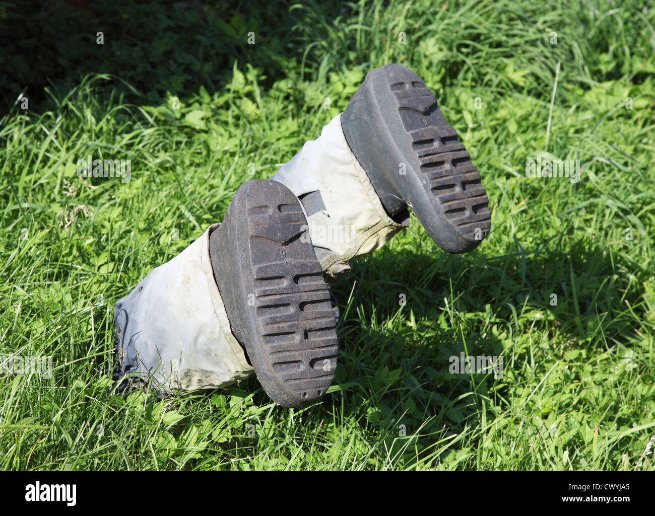 A dummy person stuck into the ground with only the feet and legs ...