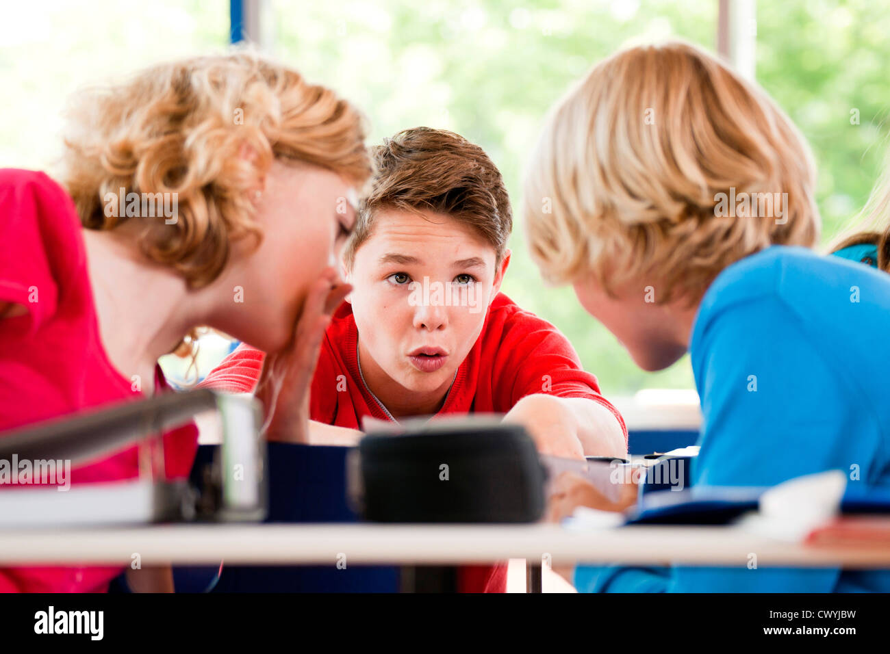 Friends whispering in classroom Stock Photo - Alamy