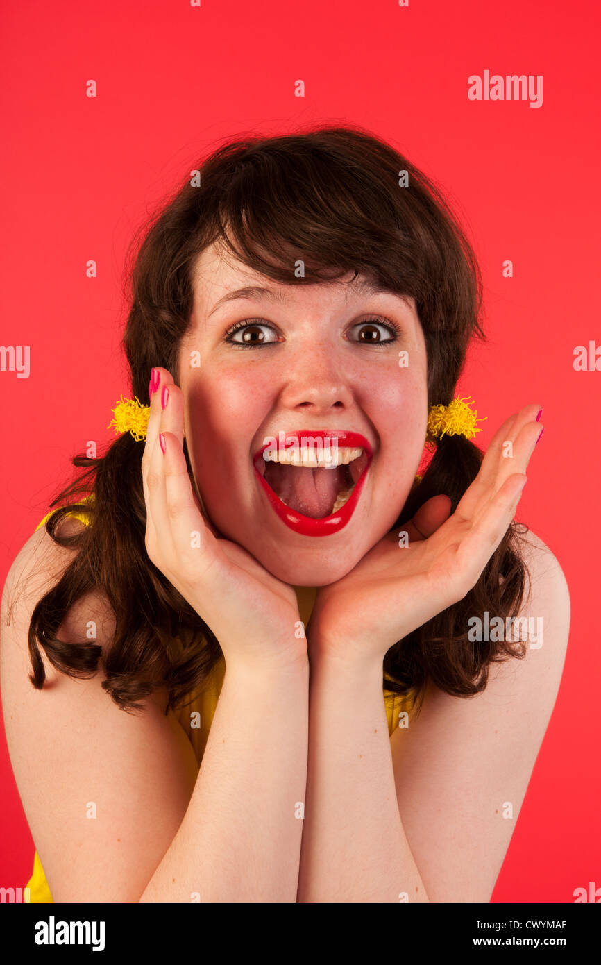 Happy young girl in yellow on red background Stock Photo - Alamy