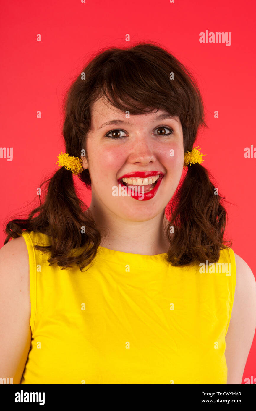 Happy young girl in yellow on red background Stock Photo - Alamy