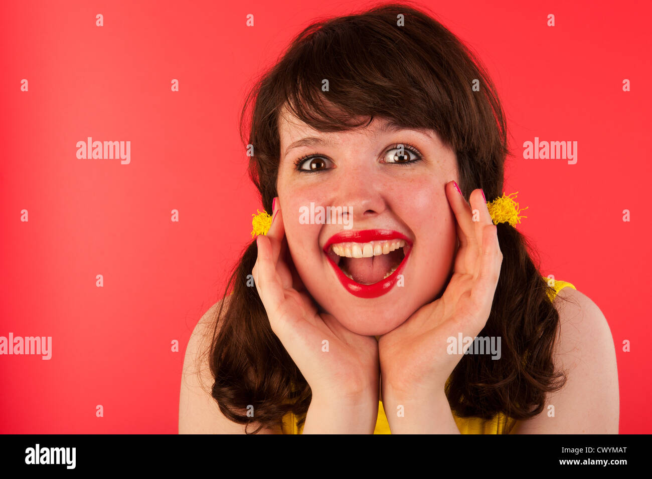 Happy young girl in yellow on red background Stock Photo - Alamy