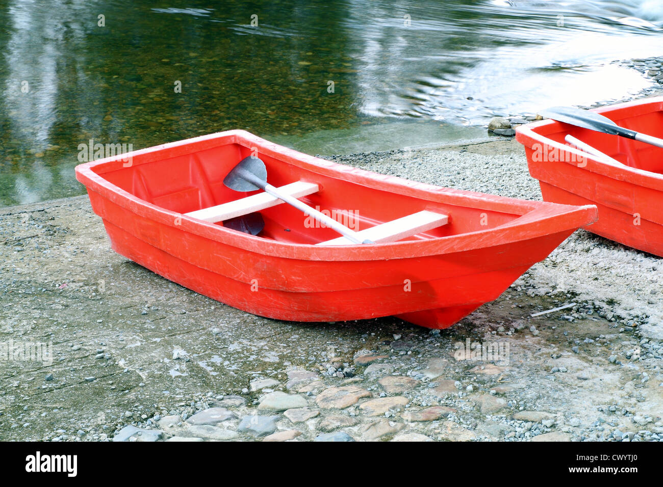two red rowboat near the river Stock Photo - Alamy