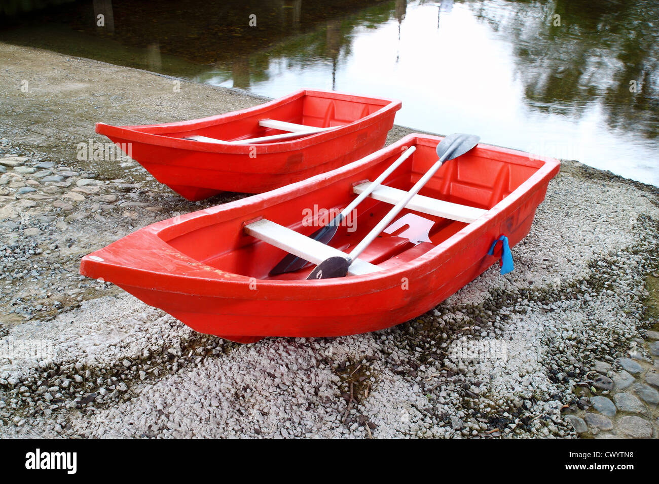 two red rowboat near the river Stock Photo - Alamy