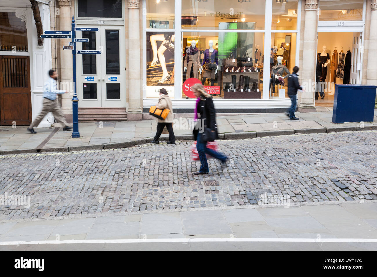 Pedestrians rush up and down along the cobbled High Street of Guildford ...